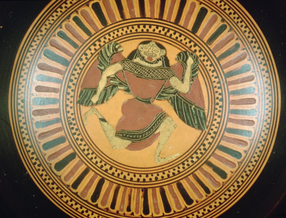 Copa de figuras negras áticas decorada con una gorgona corriendo
